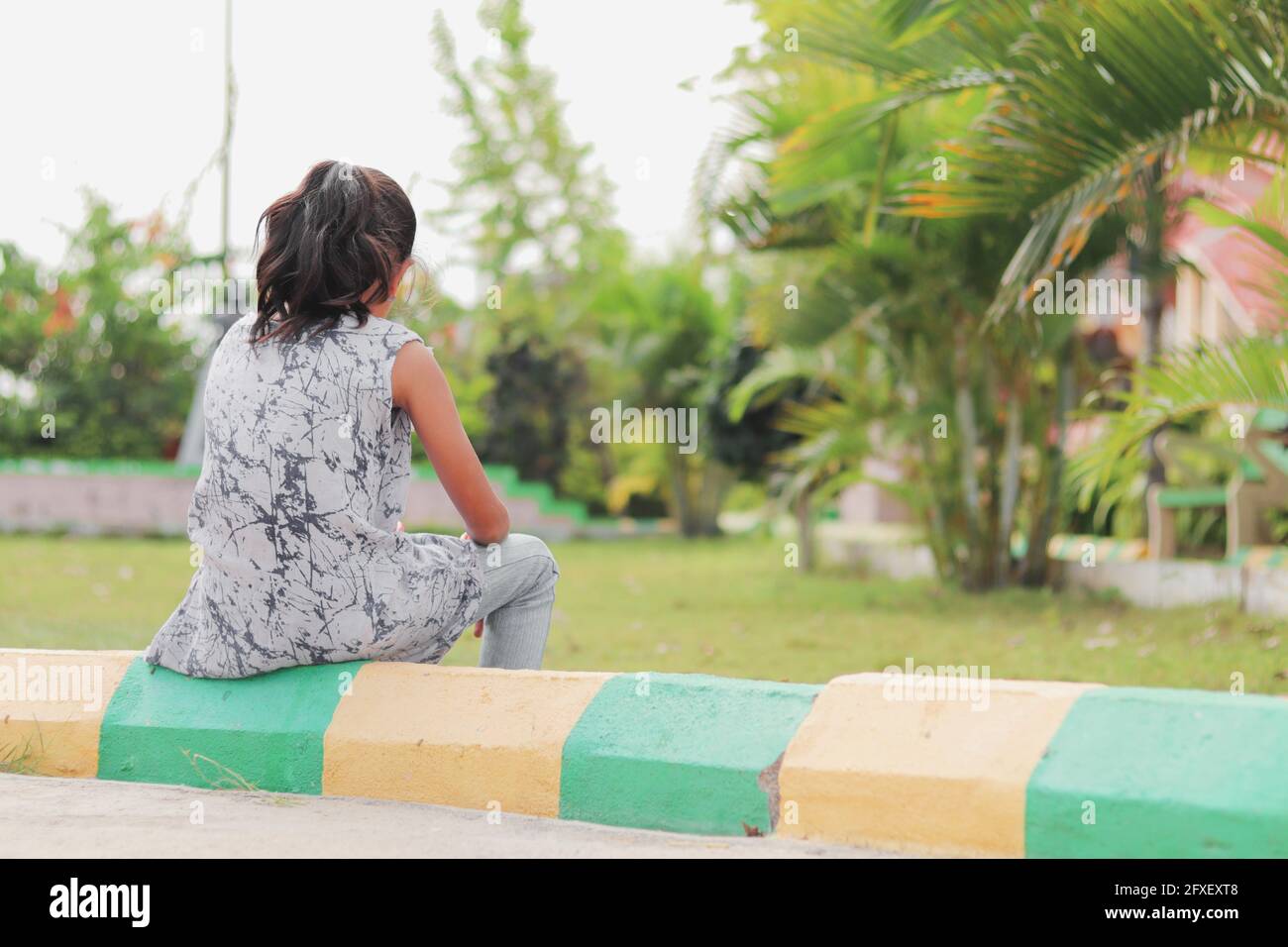 Sad girl sitting alone outside hi-res stock photography and images - Alamy
