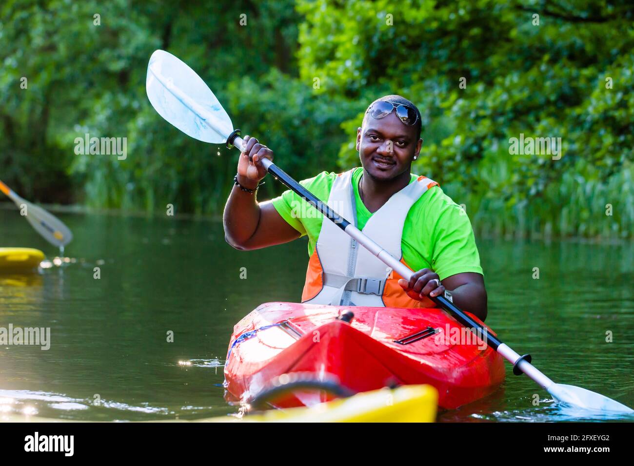 African Man paddling with canoe on forest river Stock Photo - Alamy