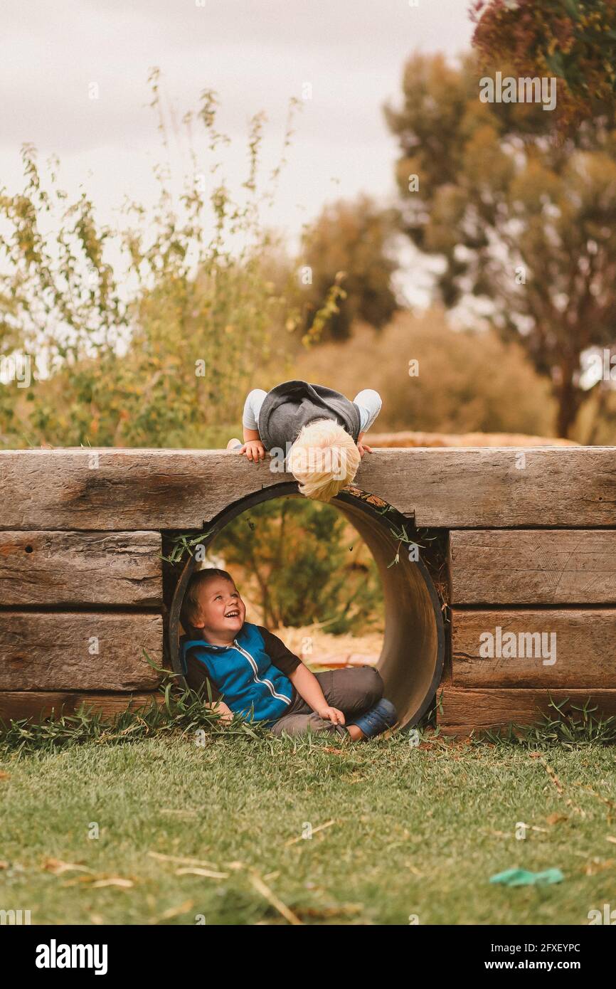 Vertical shot of two white Caucasian young kids playing together in a ...