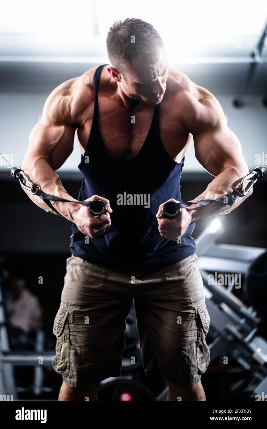 Bodybuilder doing butterfly on cable pull for better definition of his ...