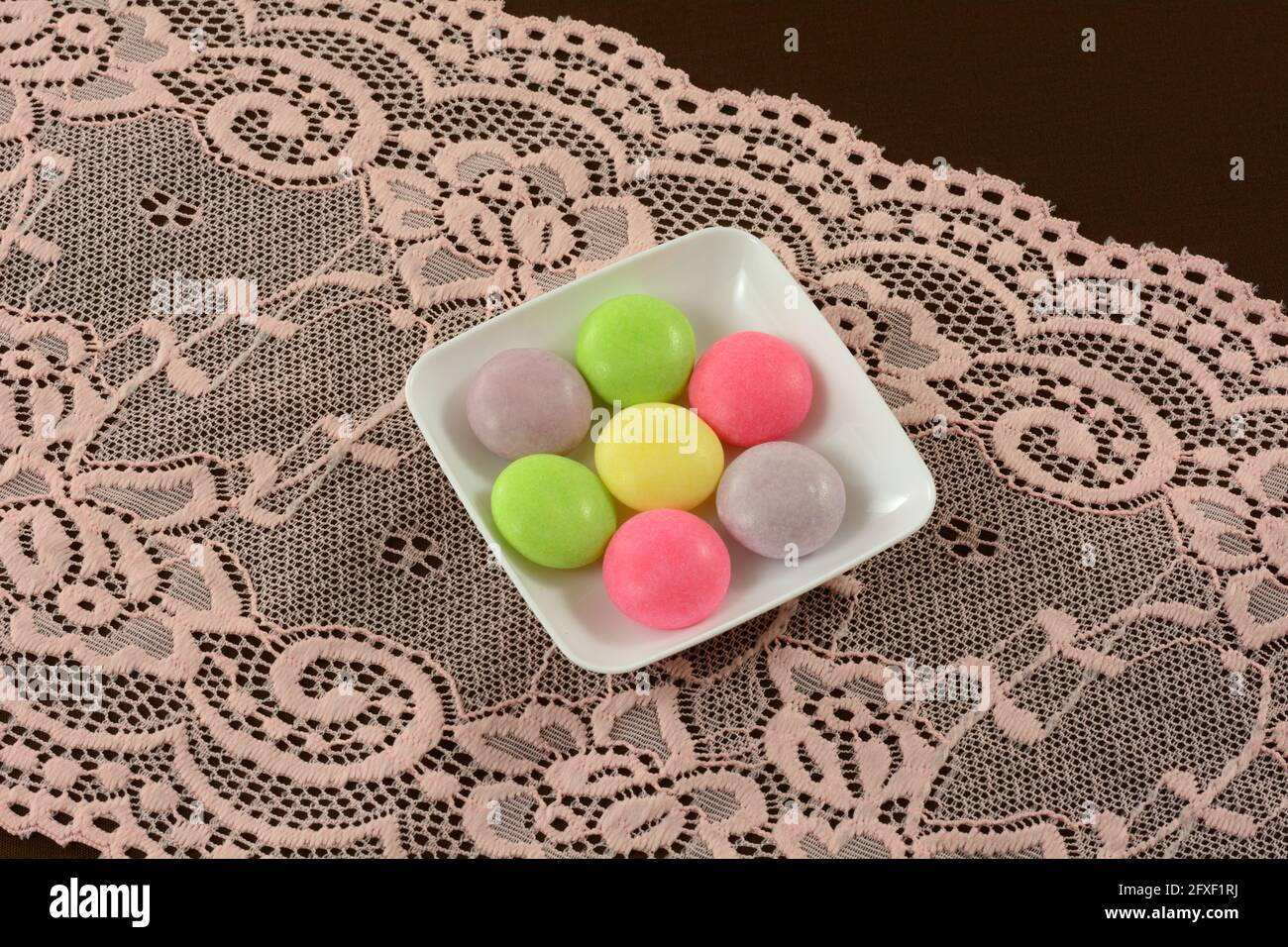 Multicolor soda pop mint candies small white candy dish on pink lace ...