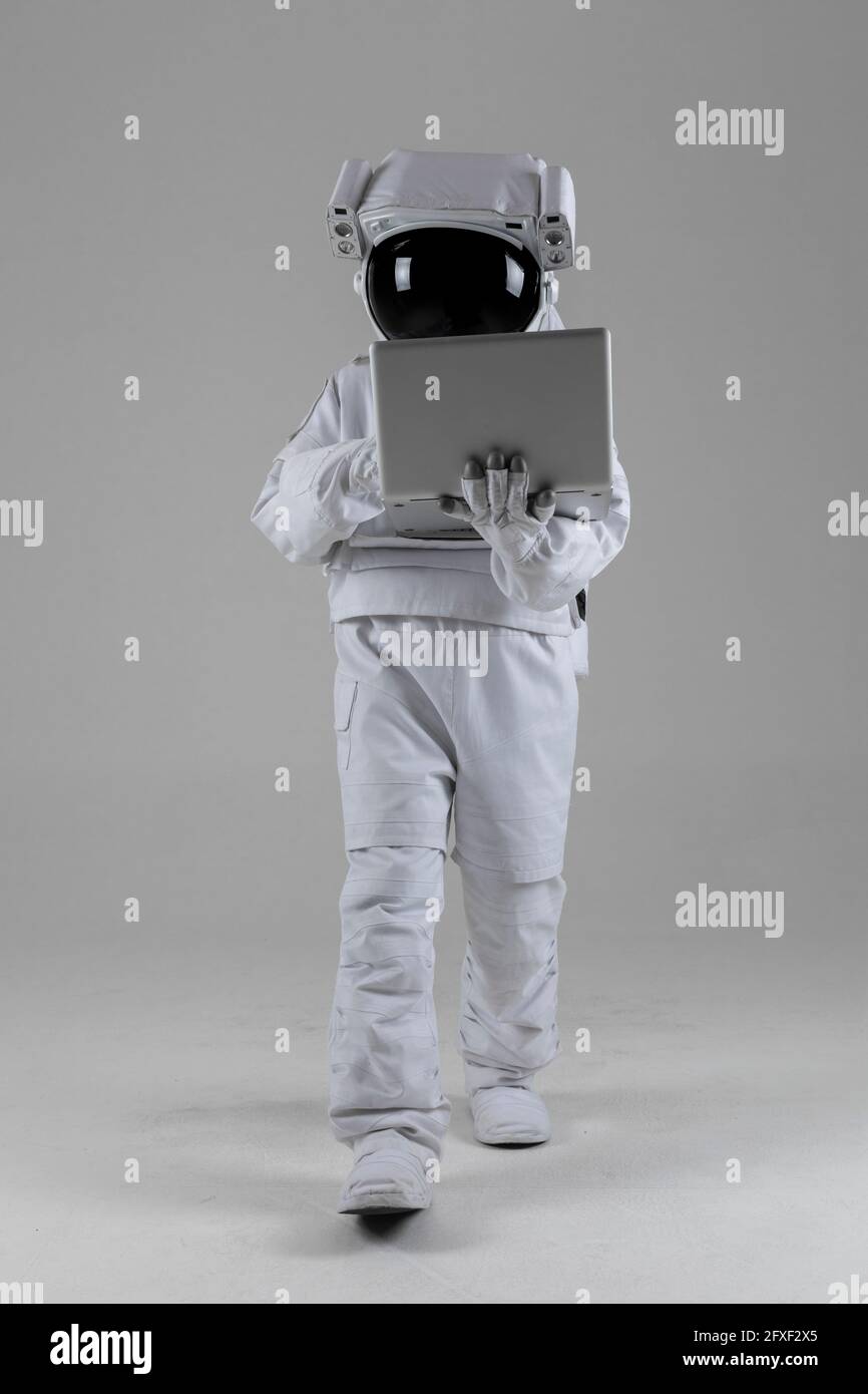 astronaut walking while using laptop computer device, white background ...