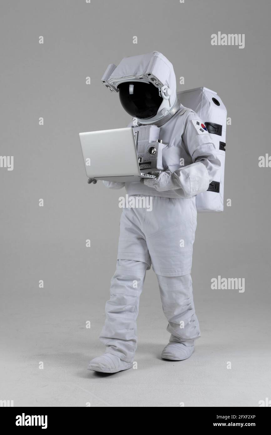 astronaut walking while using laptop computer device, white background ...
