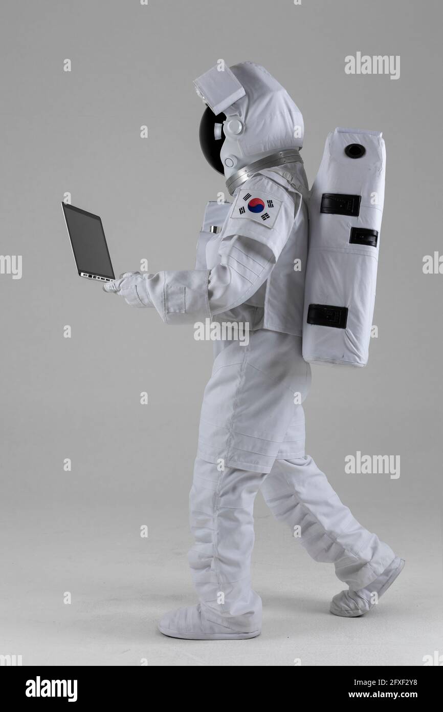 astronaut walking while using laptop computer device, white background ...