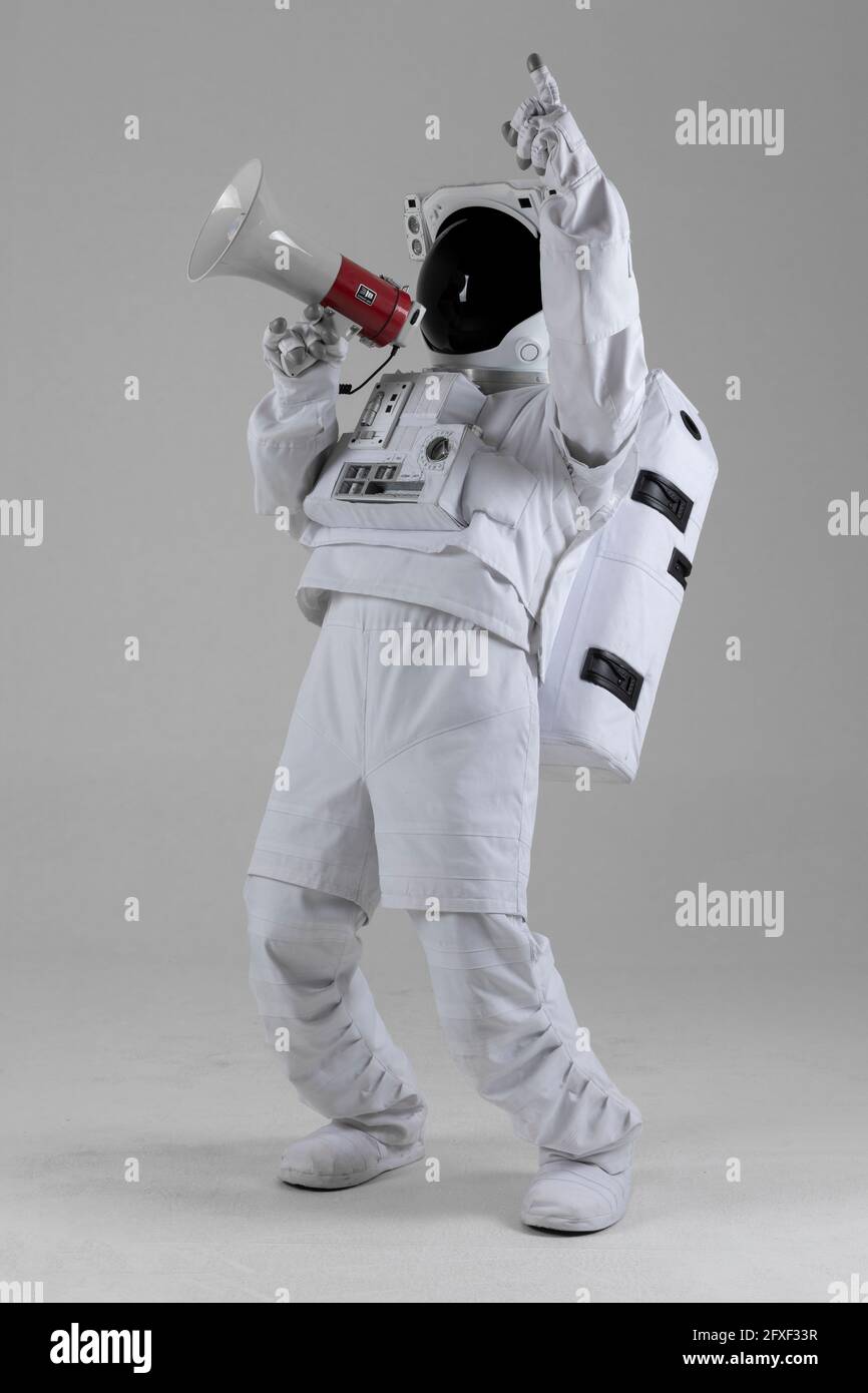 Astronaut shouting with megaphone, white background Stock Photo - Alamy