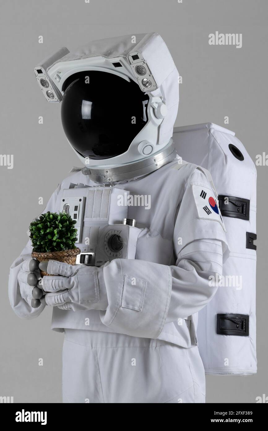 Astronaut holding a potted plant, white background Stock Photo - Alamy
