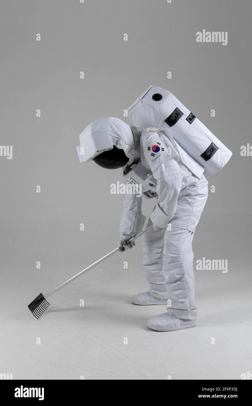 Astronaut using farm equipment, white background Stock Photo - Alamy