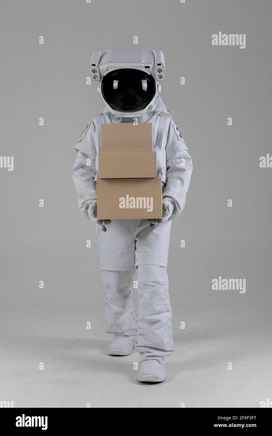 Astronaut walking holding a courier box, white background Stock Photo ...