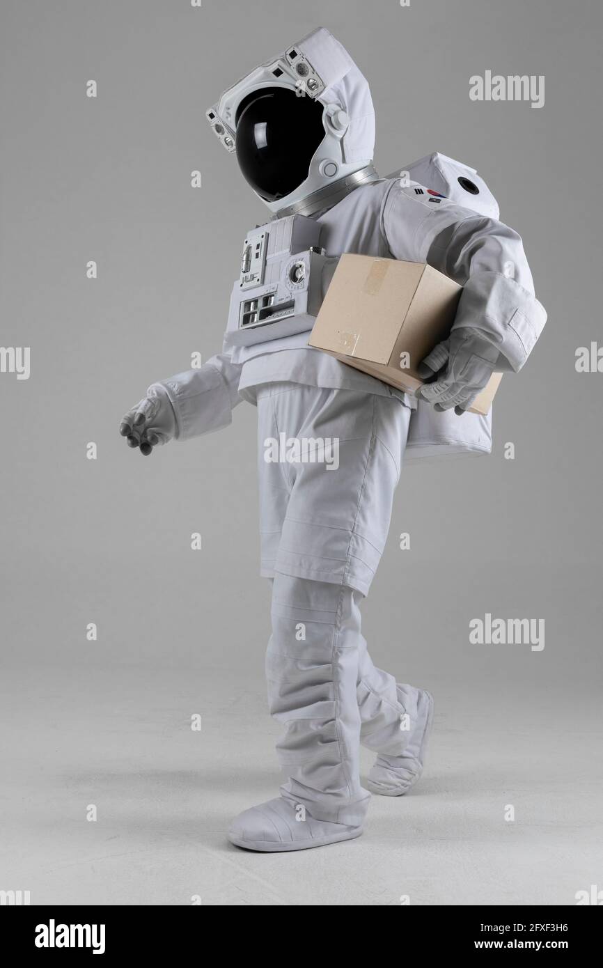 Astronaut walking holding a courier box, white background Stock Photo ...