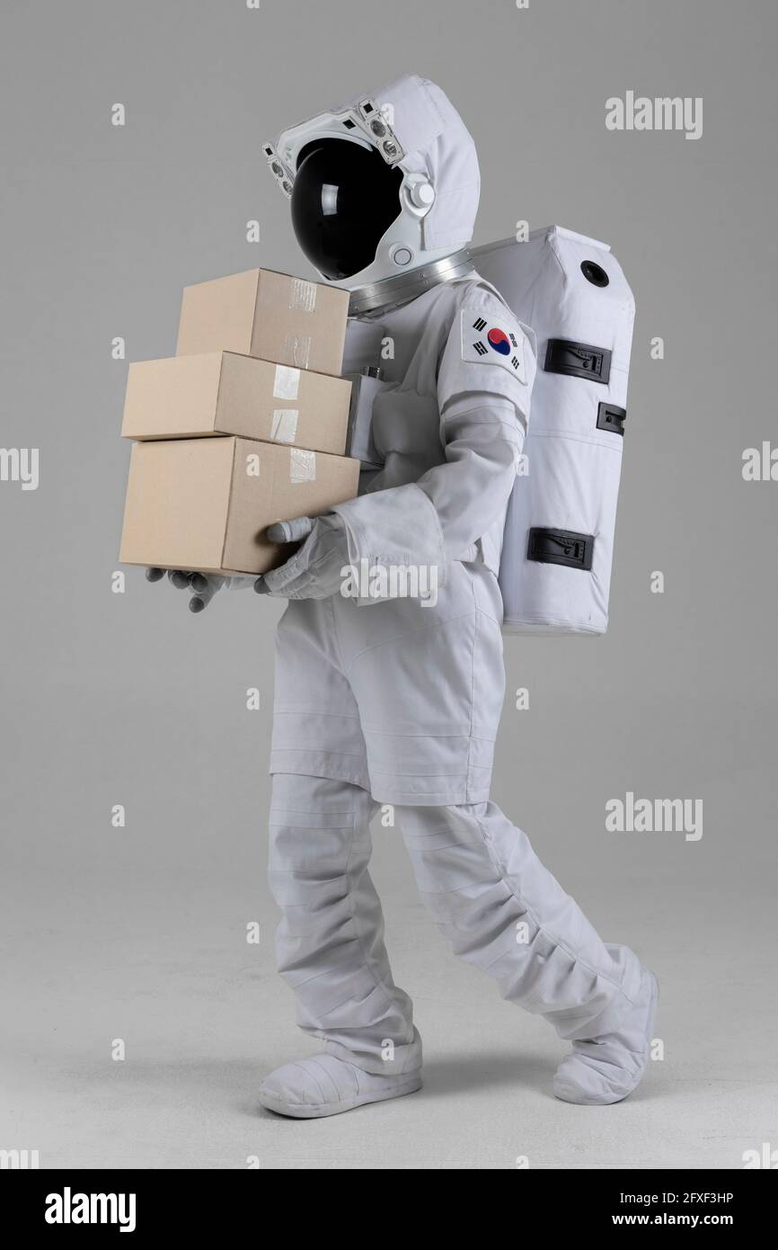 Astronaut walking holding a courier box, white background Stock Photo ...