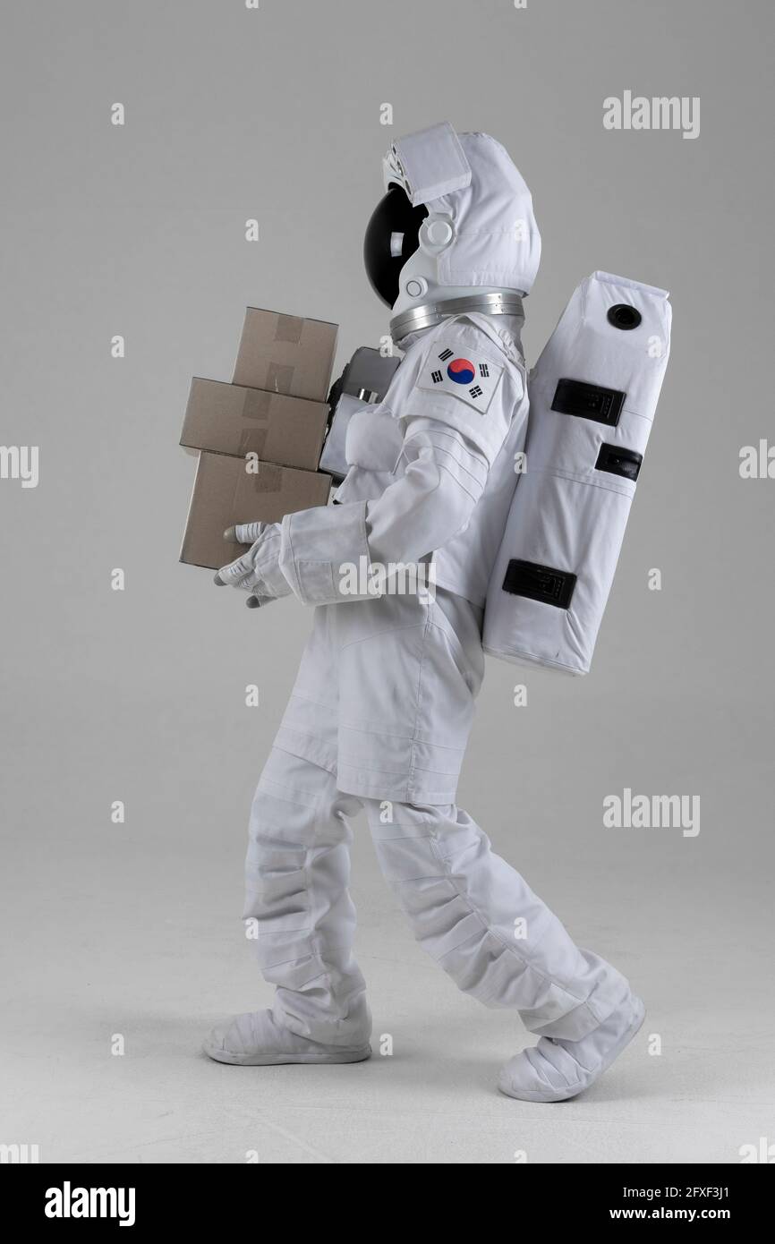 Astronaut walking holding a courier box, white background Stock Photo ...