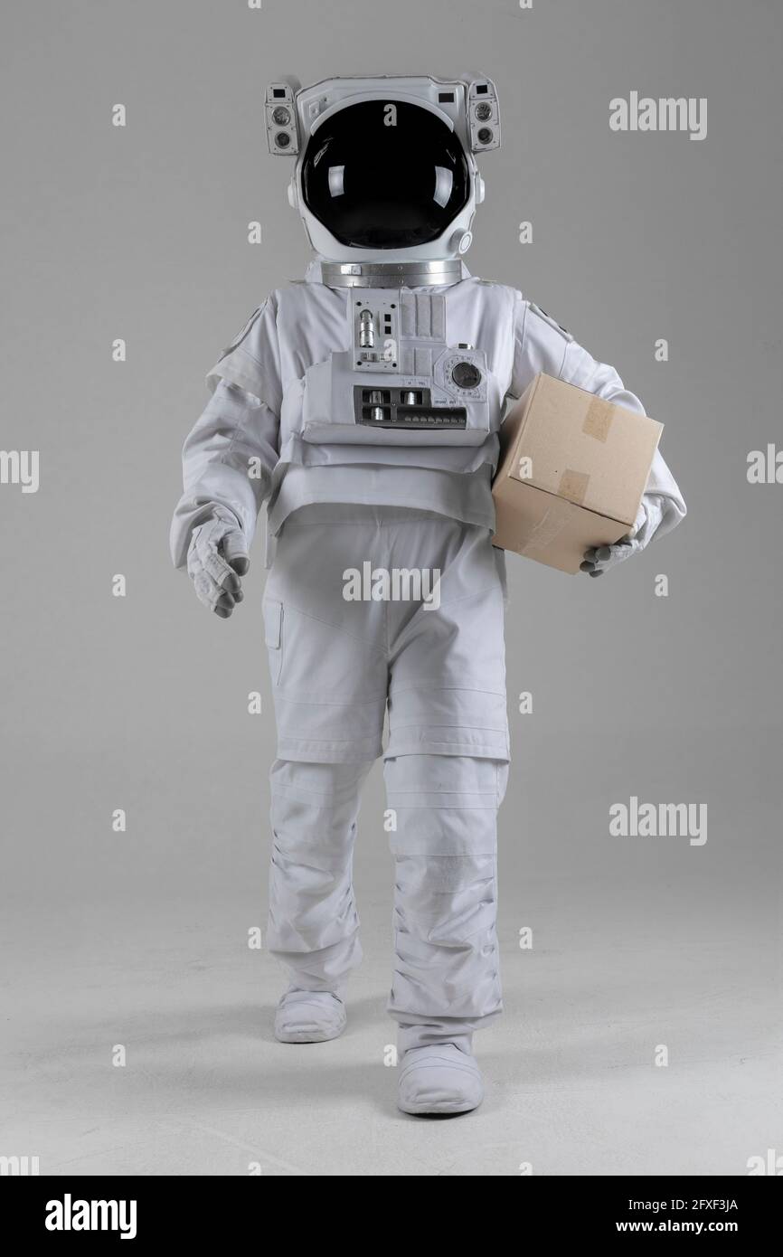 Astronaut walking holding a courier box, white background Stock Photo ...