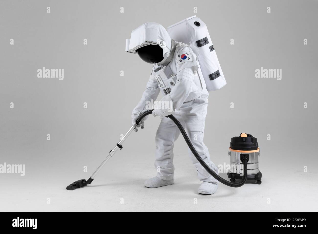 astronaut cleaning floor with vacuum cleaner, white background Stock ...