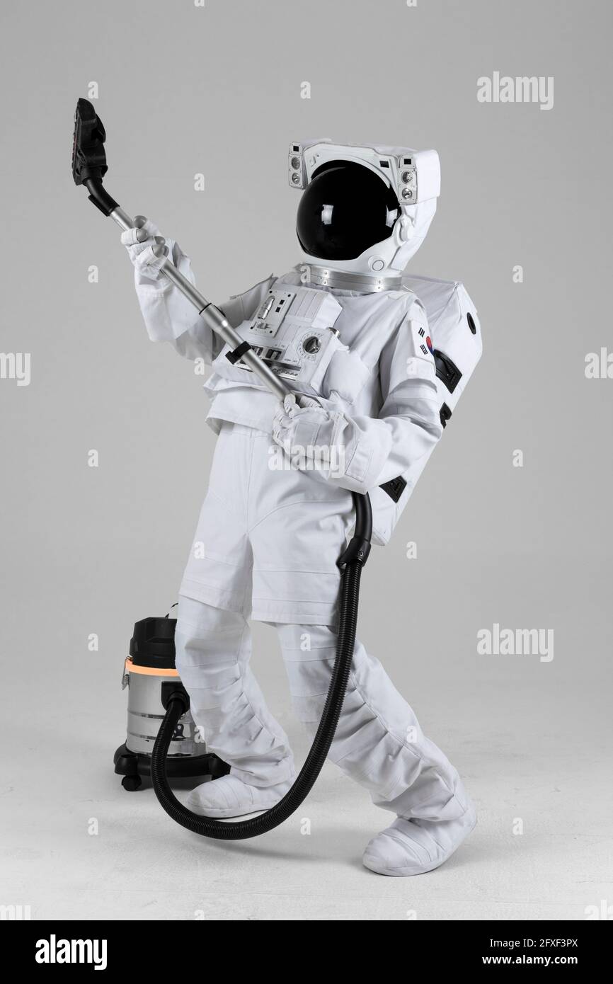 astronaut playing with vacuum cleaner, white background Stock Photo - Alamy