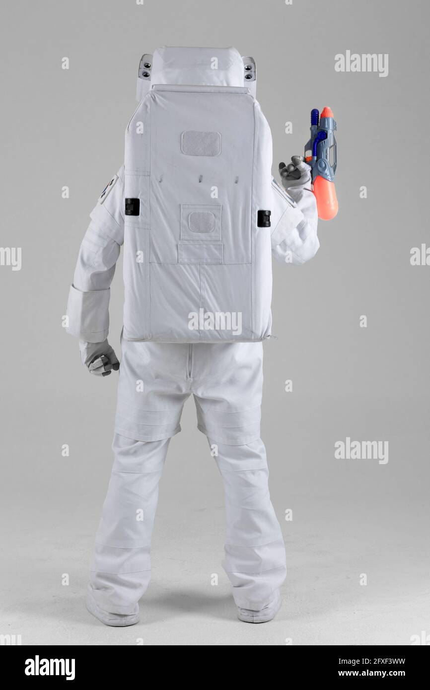 astronaut holding a toy water gun, white background Stock Photo - Alamy