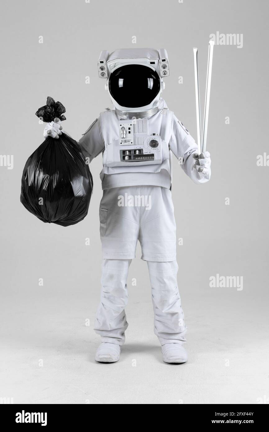 Picking up trash, astronaut in white background Stock Photo - Alamy