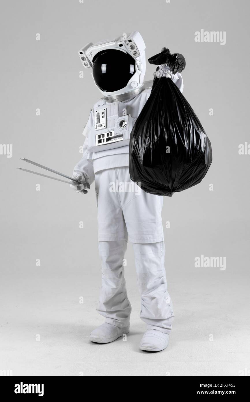 Astronaut showing garbage bags, white background Stock Photo - Alamy