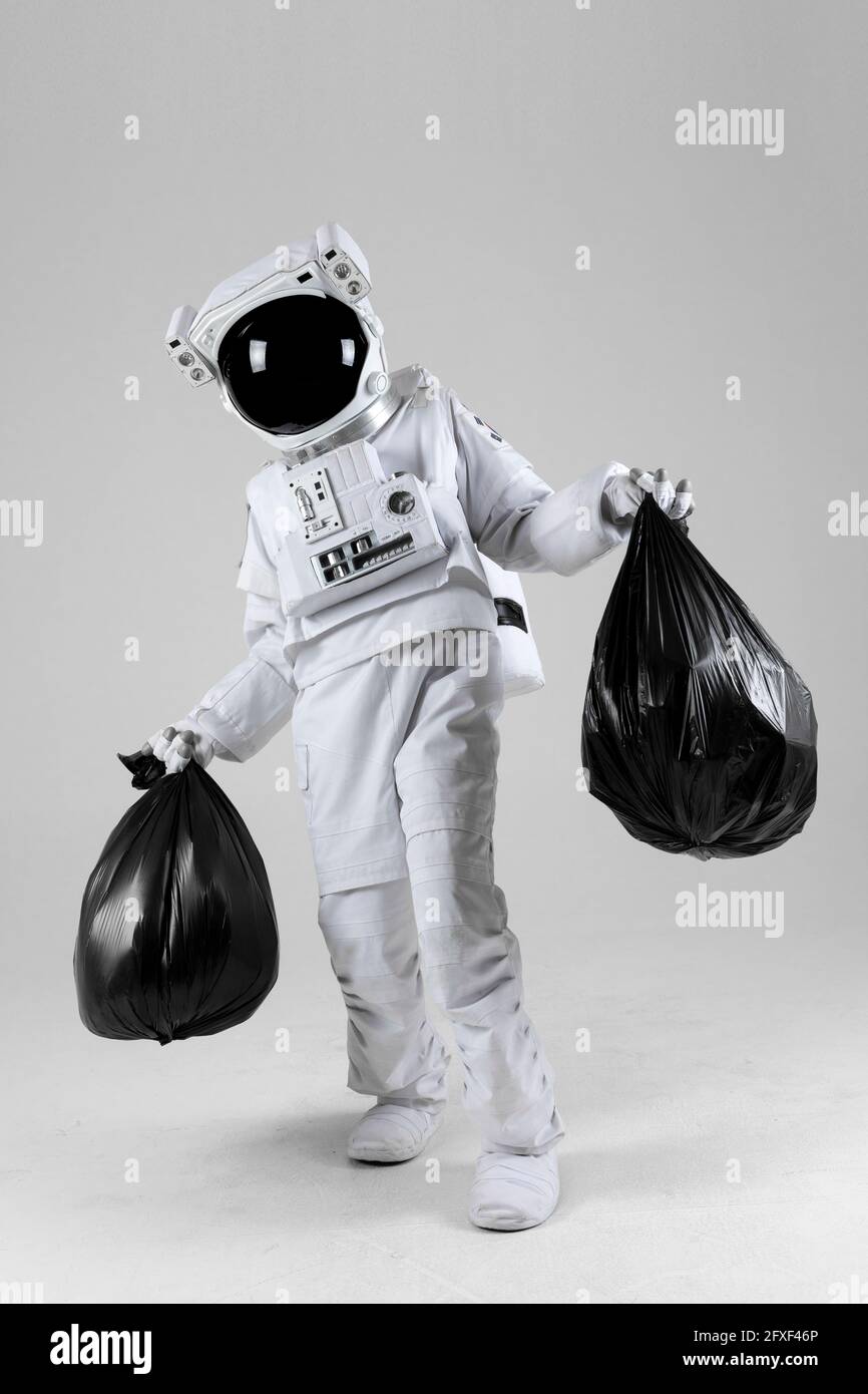 Astronaut with garbage bags, white background Stock Photo - Alamy