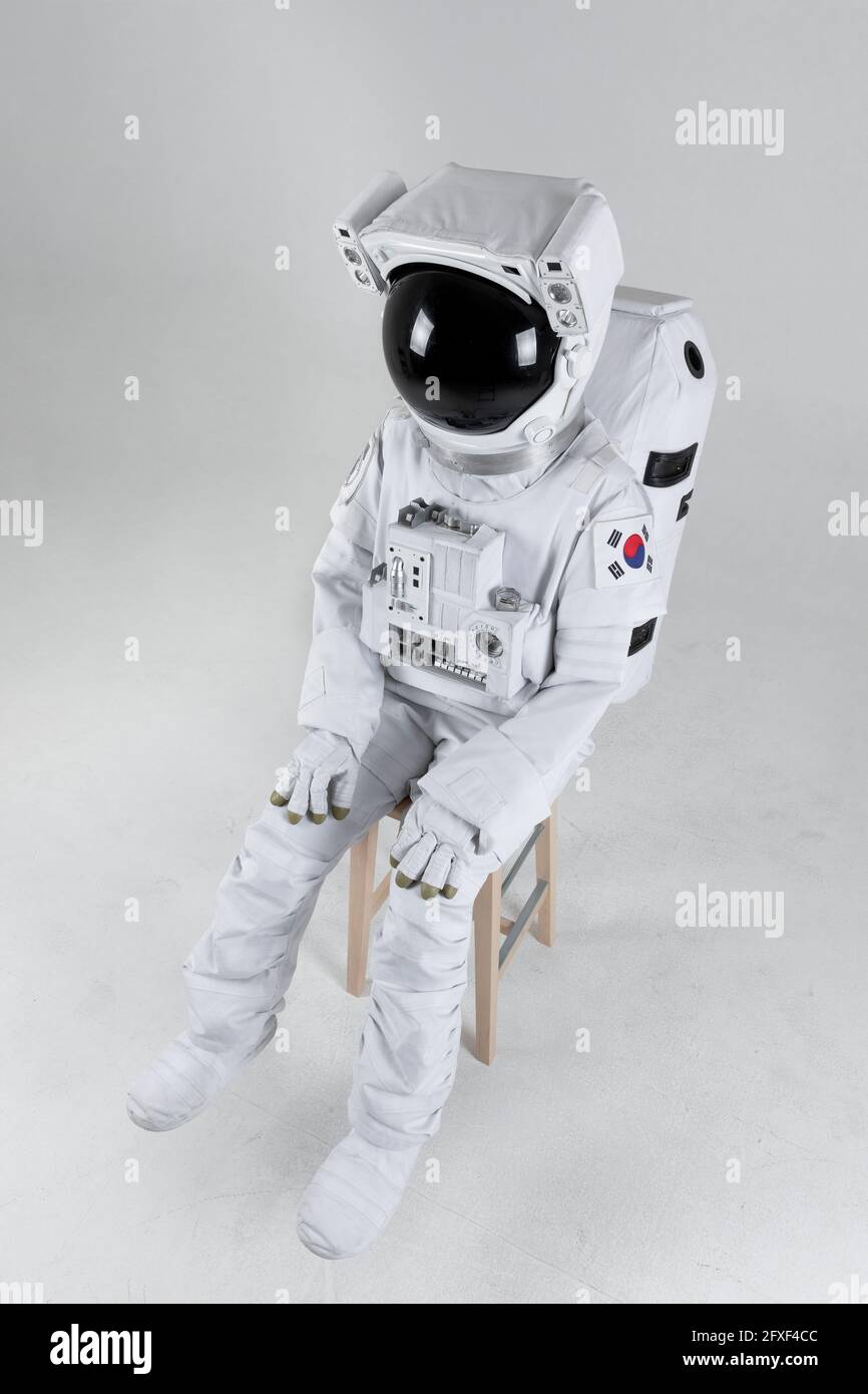 Astronaut sitting on a wooden chair, white background Stock Photo - Alamy