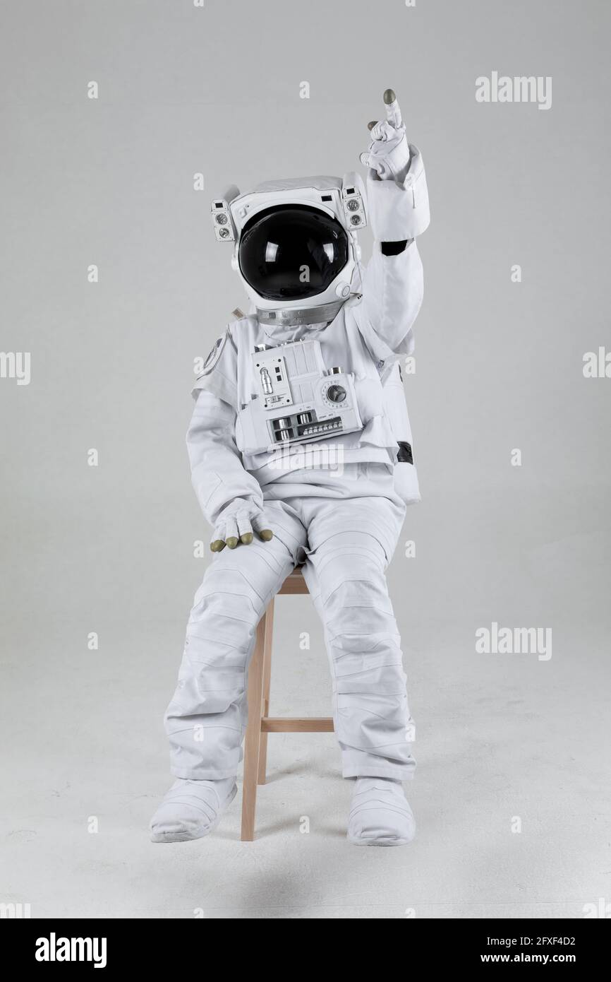Astronaut sitting on a wooden chair, white background Stock Photo - Alamy