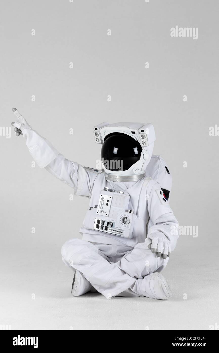 Astronaut pointing one side, white background Stock Photo - Alamy