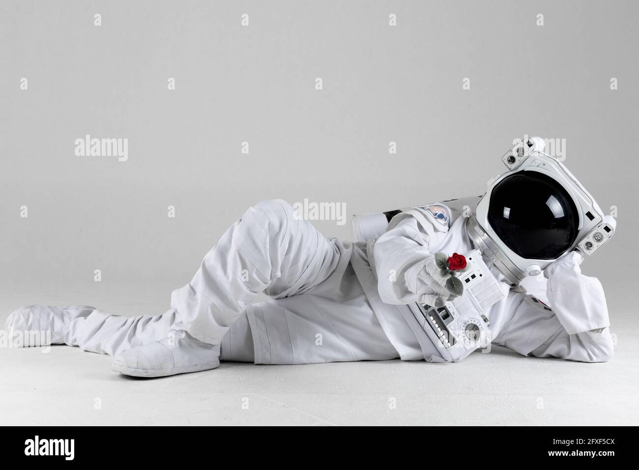 Astronaut lying on side with rose, white background Stock Photo - Alamy