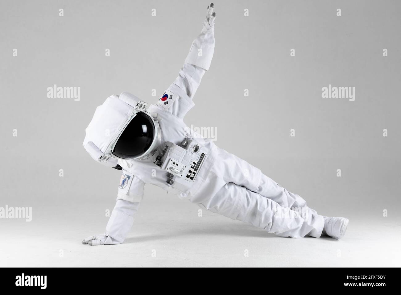 Astronaut doing exercise, white background Stock Photo - Alamy