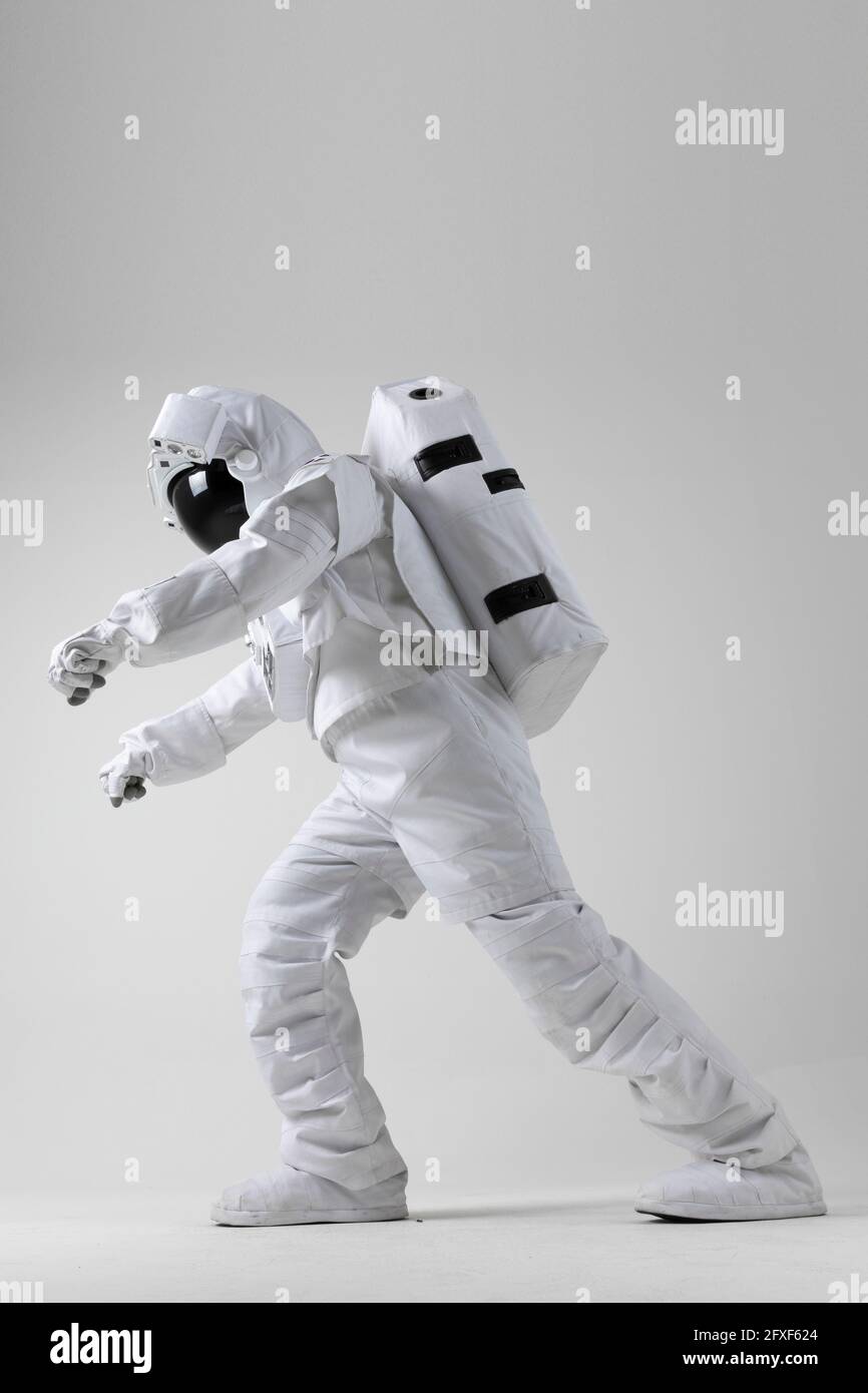 Astronaut stretching before exercise, white background Stock Photo - Alamy