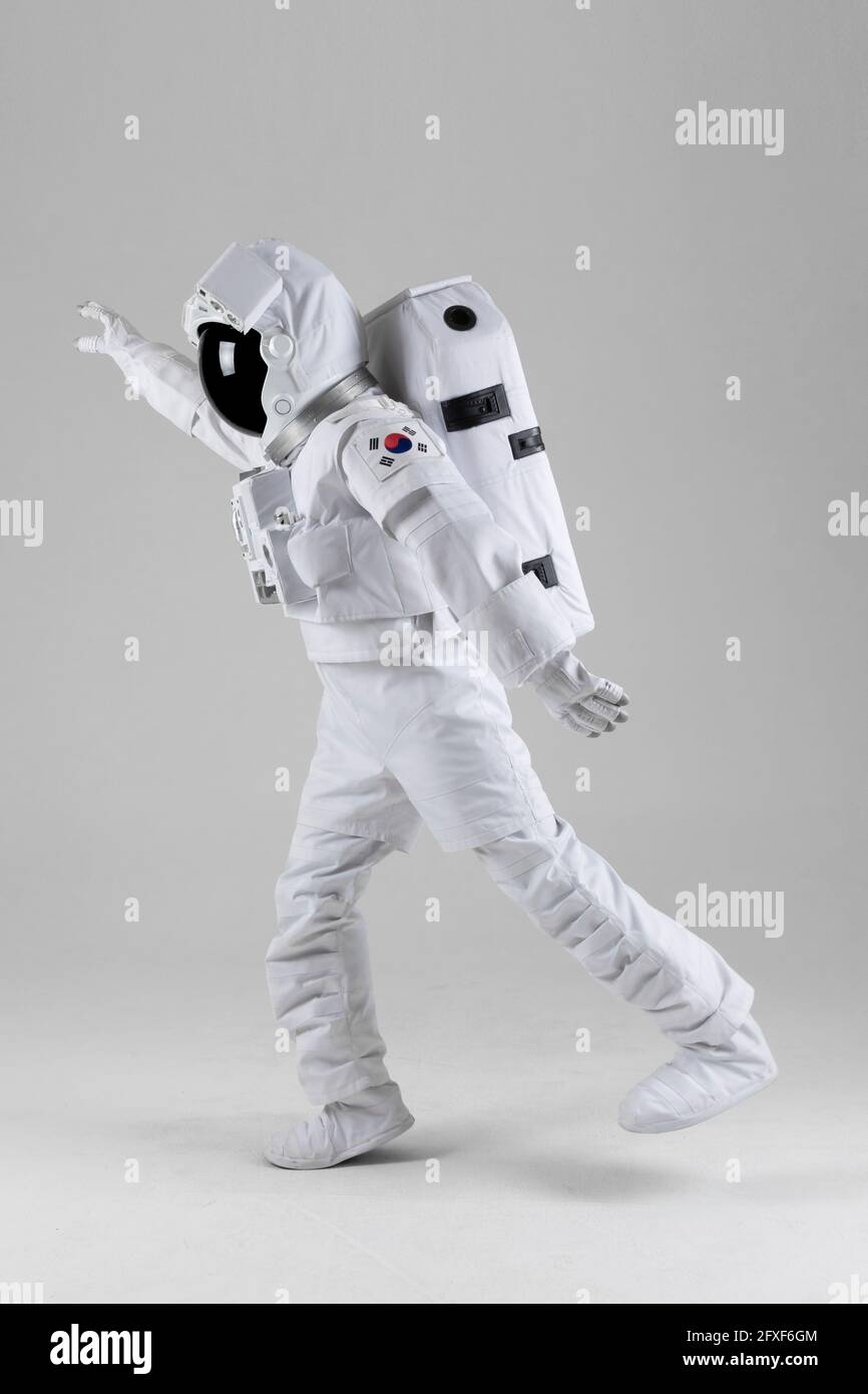 Astronaut stretching hand, white background Stock Photo - Alamy