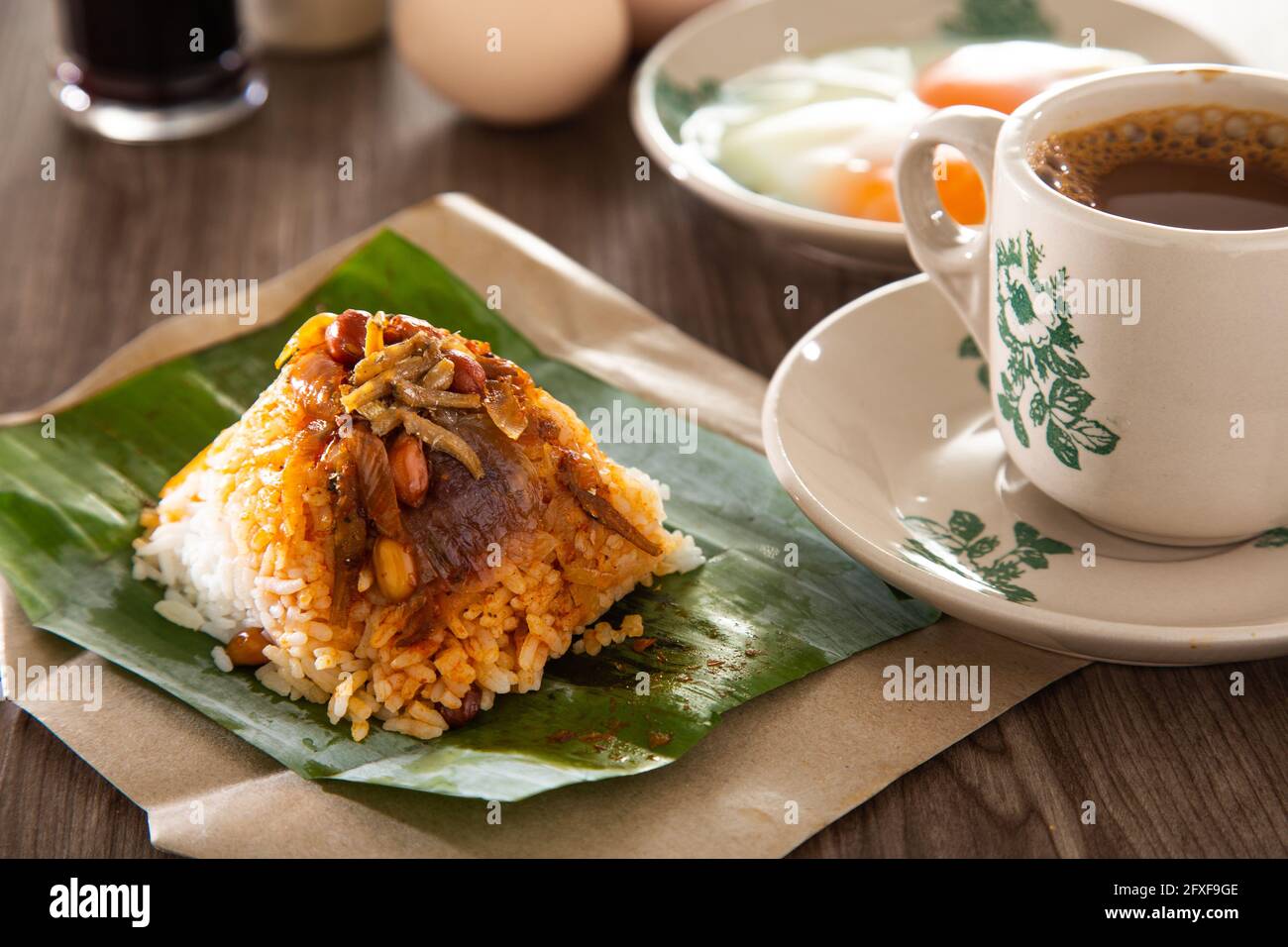 Common oriental breakfast set in Malaysia consisting of coffee, nasi lemak, toast bread and half ...