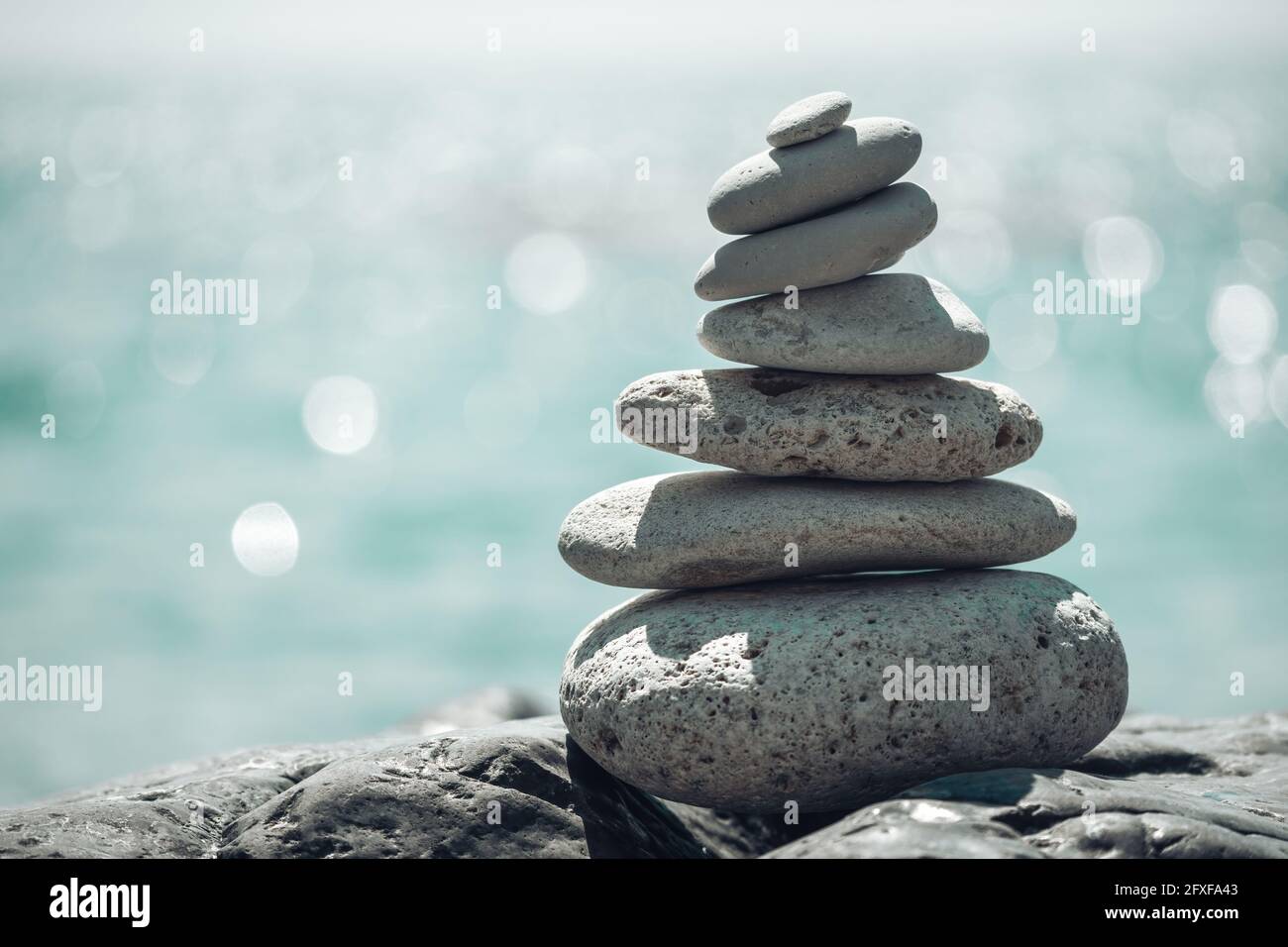 Pyramid stones on the seashore on a sunny day on the blue sea ...