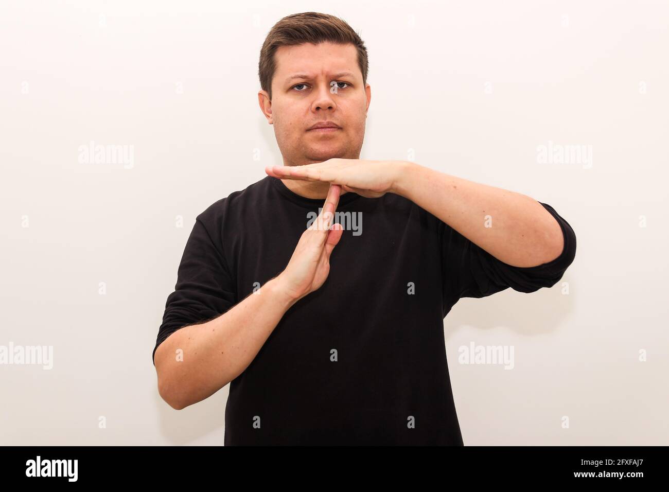 A Caucasian male showing time out sign with hands Stock Photo - Alamy