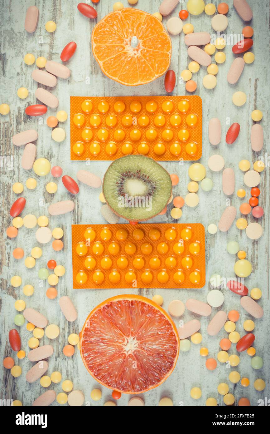 Fresh natural fruits containing vitamins and medical pills. Choice ...