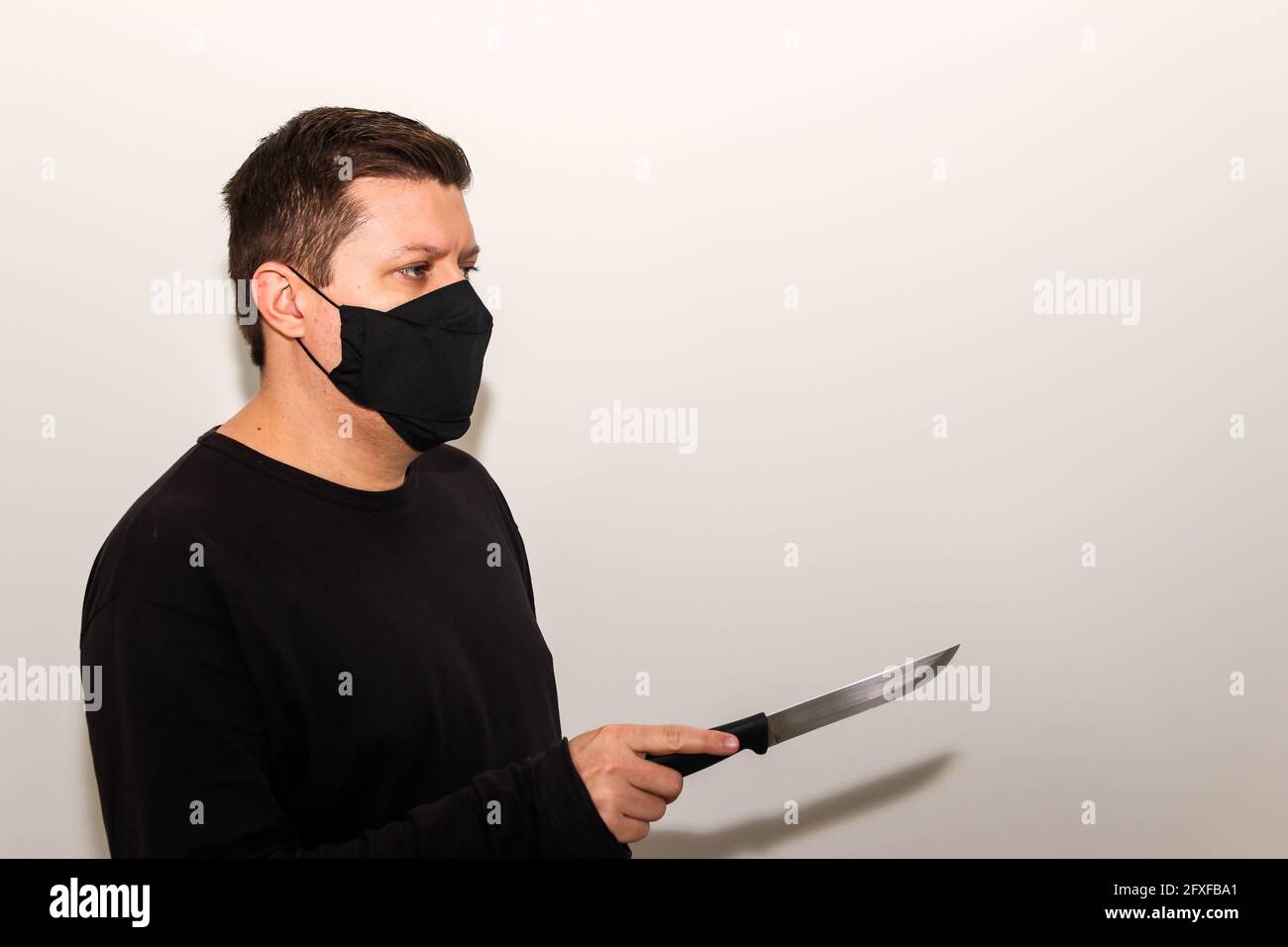 Serious Brazilian male with a face mask threatening with a knife Stock ...