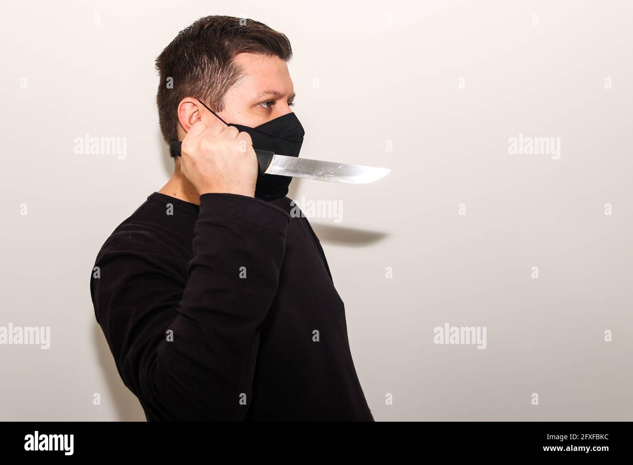 Serious Brazilian male with a face mask threatening with a knife Stock ...
