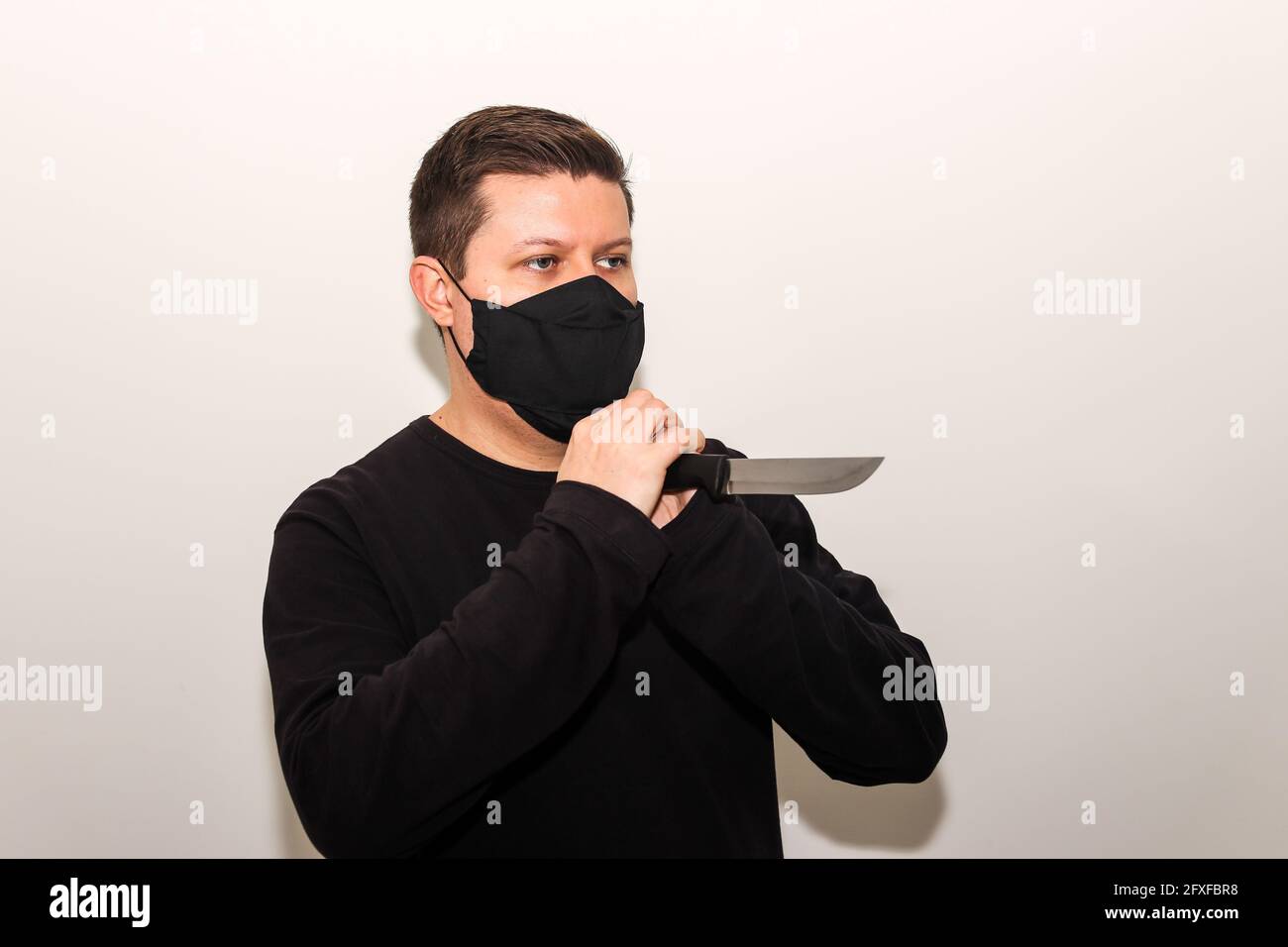 Serious Brazilian male with a face mask threatening with a knife Stock ...