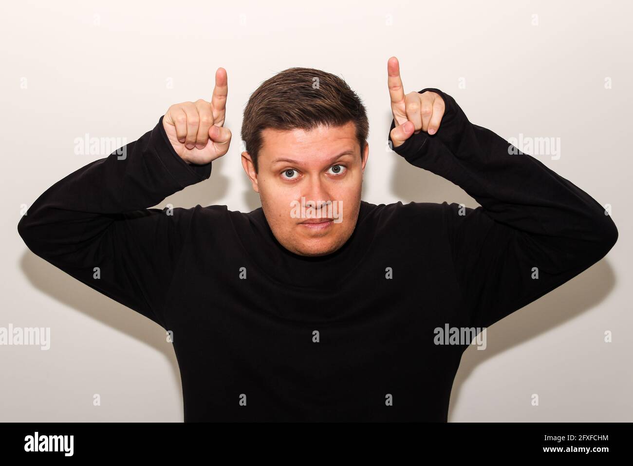 Brazilian male showing horns sign with fingers Stock Photo - Alamy