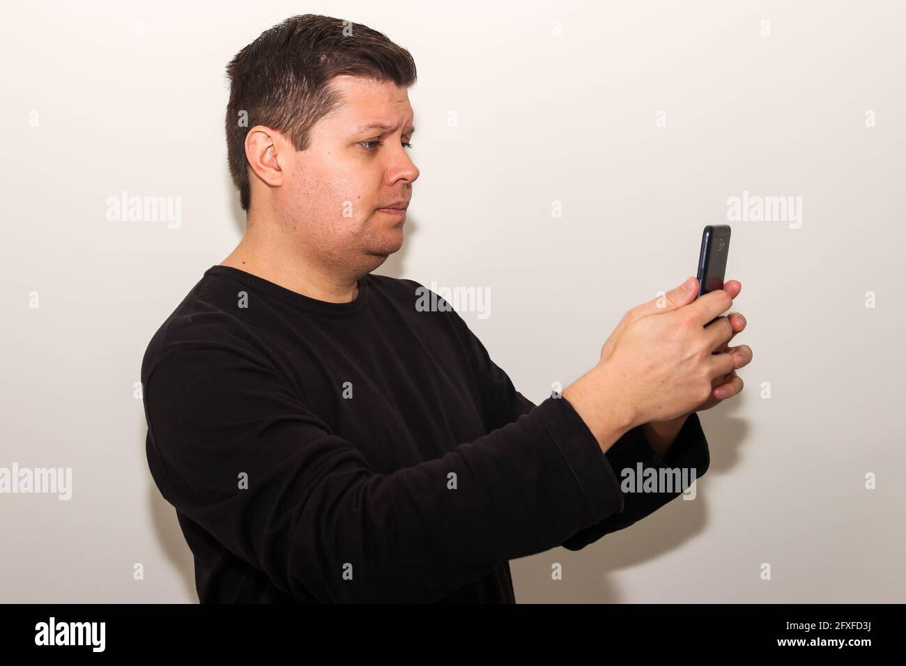 Brazilian male taking a photo with a phone Stock Photo - Alamy