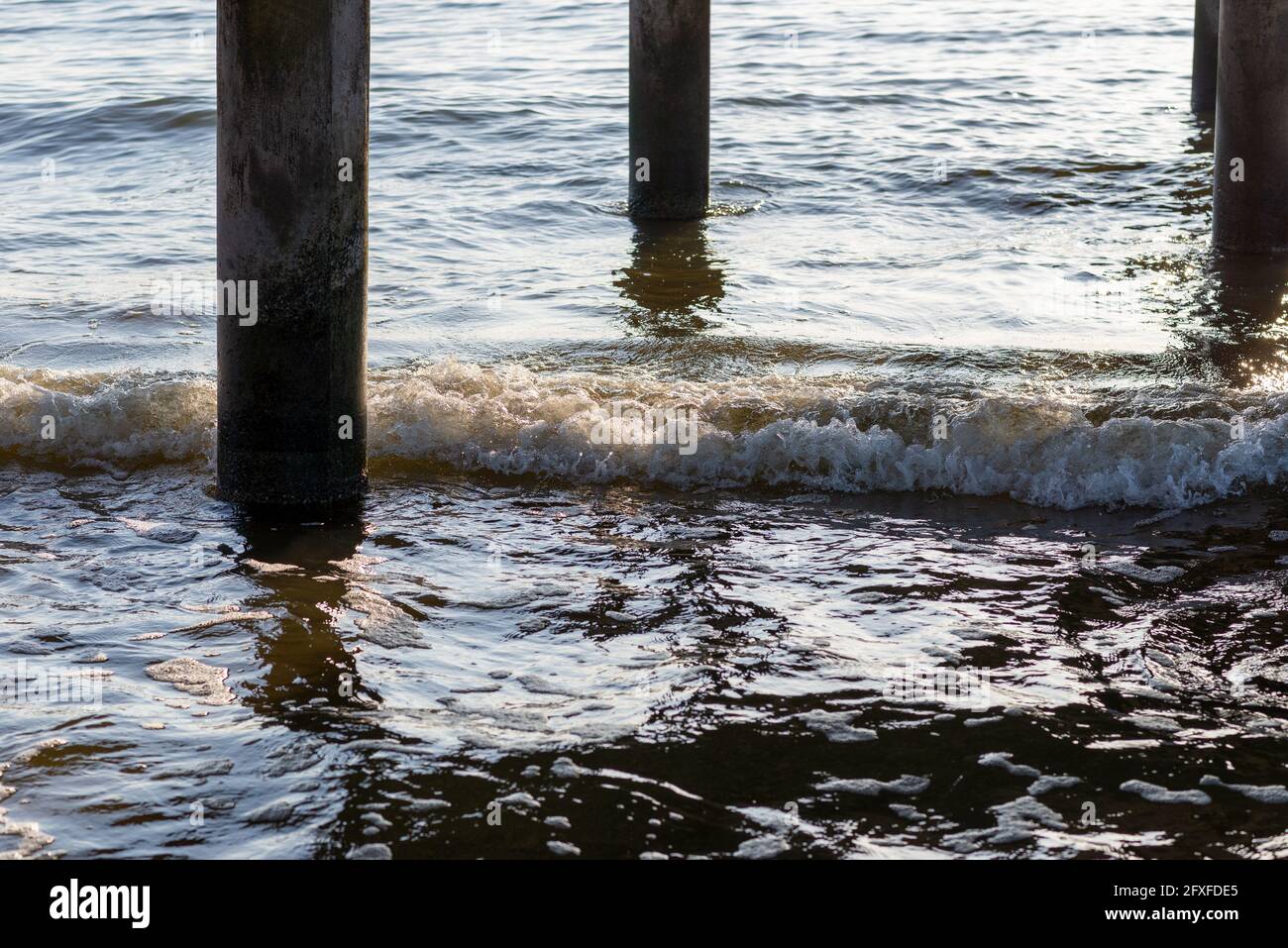 Columnar bridge piers at sunset.View under the bridge into sea with ...