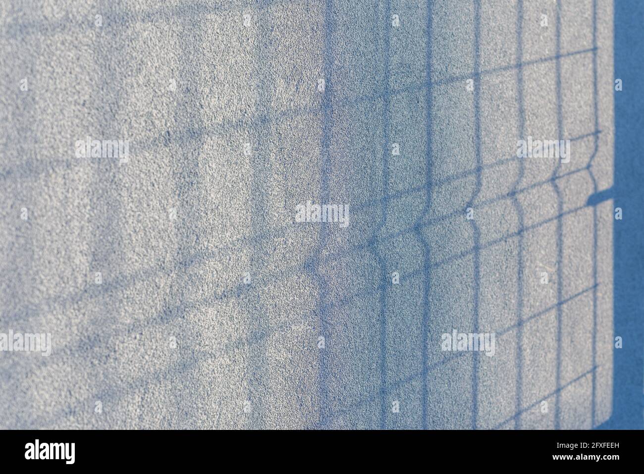 The shadow of the fence on the gray blue plastered wall. Fence with ...