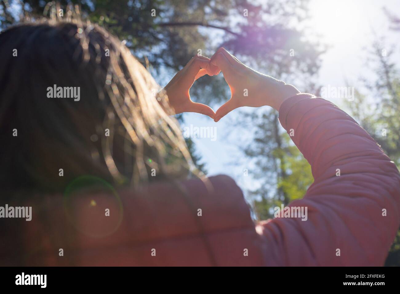 Hands in heart shape. Teenage girl hands heart shape on against blurry ...