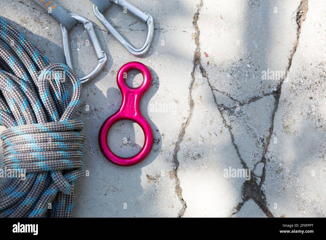 Coiled climbing rope and steel carabiner. Mountain climbing equipment ...
