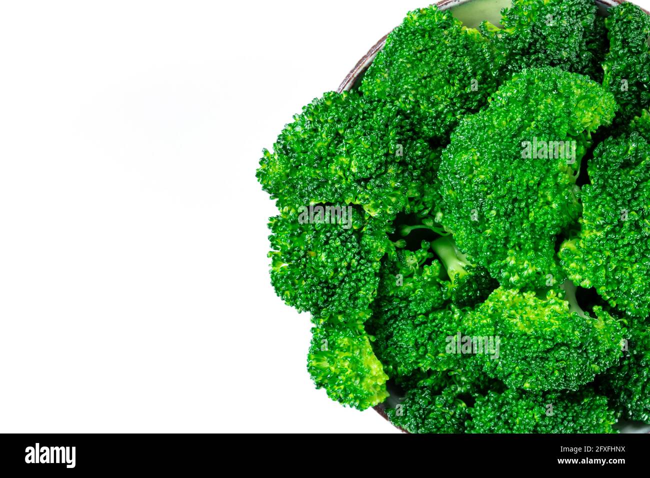Cooked broccoli close-up, overhead shot on a white background with copy ...