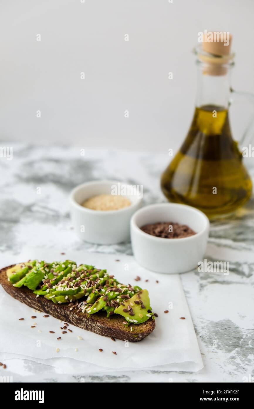 Healthy avocado toast on concrete background. Wholegrain bread, sesame ...