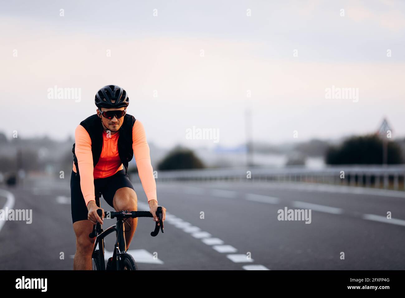 Young guy with muscular body cycling on road Stock Photo - Alamy