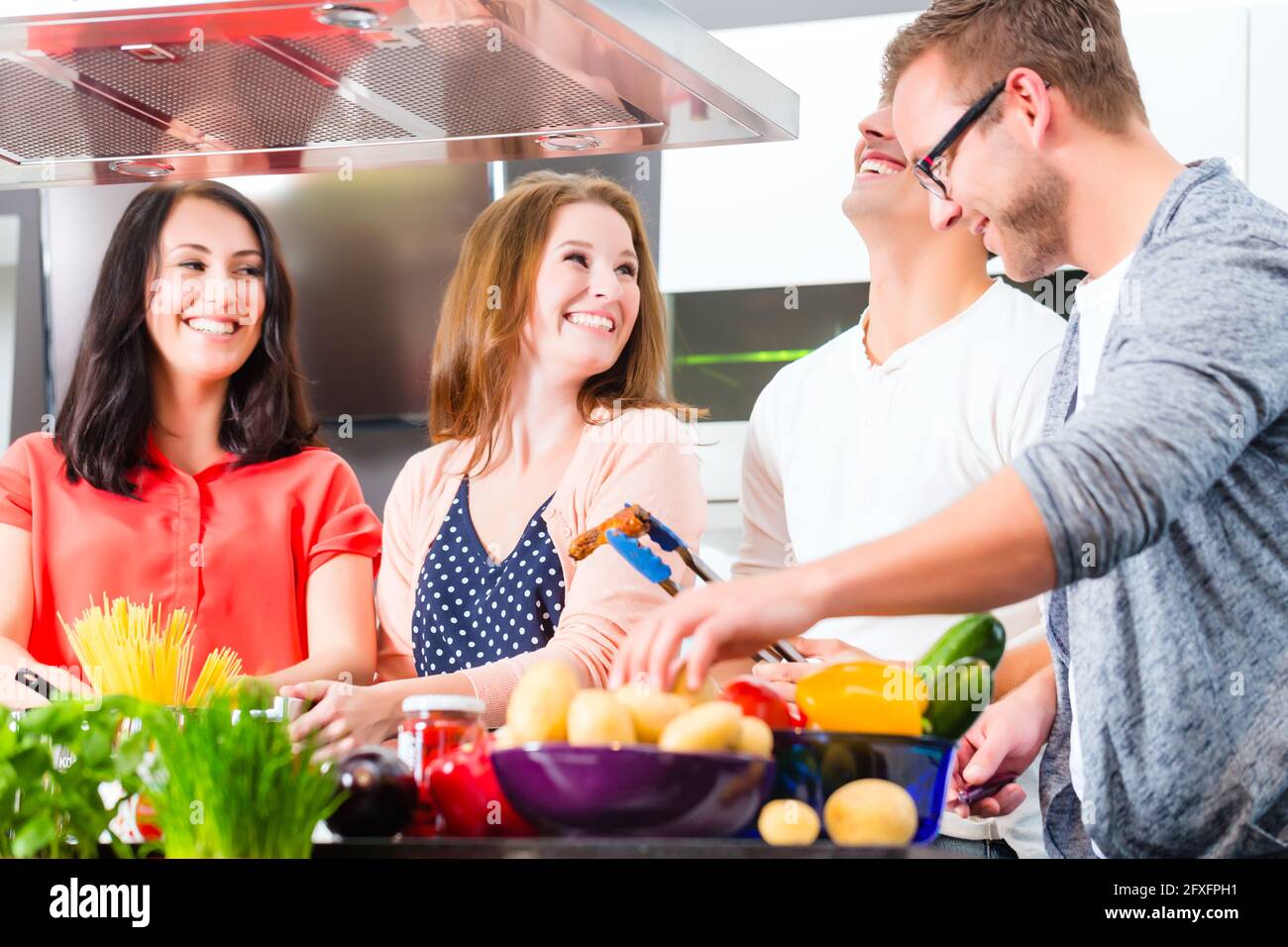 Friends cooking spaghetti and meat in domestic kitchen Stock Photo - Alamy