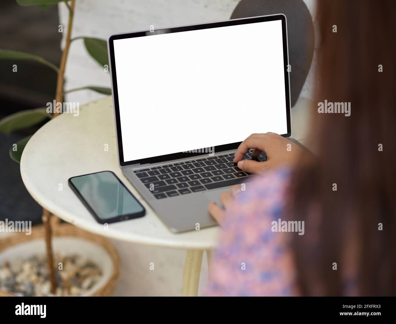 Close up view of female hand typing on laptop keyboard on white round ...