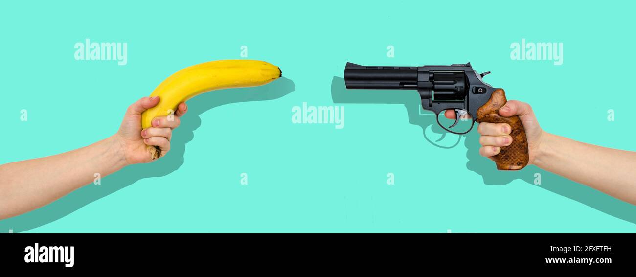 hand with a banana and a hand with gun Stock Photo - Alamy