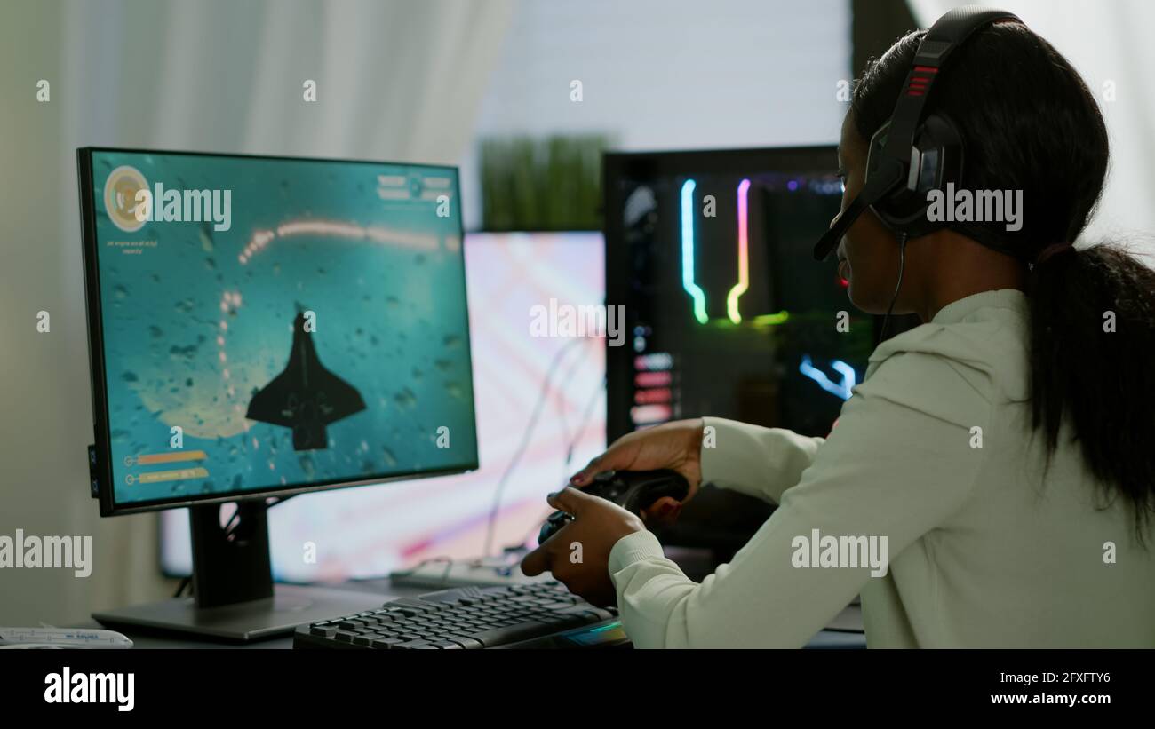 Pro african gamer playing online space shooter game on powerful ...