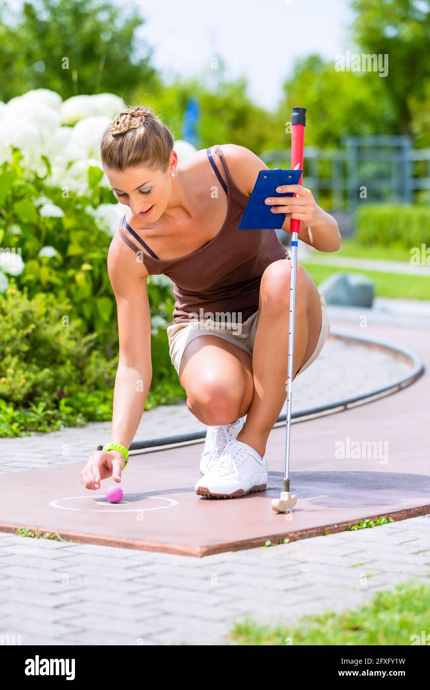 Woman playing miniature golf Stock Photo - Alamy